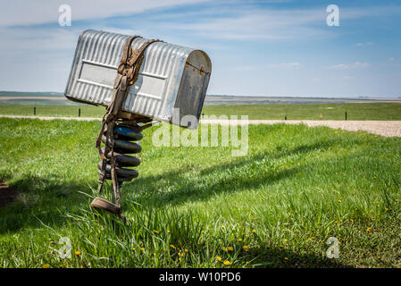 A row of three old metal farmers mailboxes on the prairies in rural ...