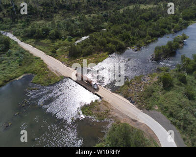 Aerial of a fully loaded Logging truck crossing causeway over the ...