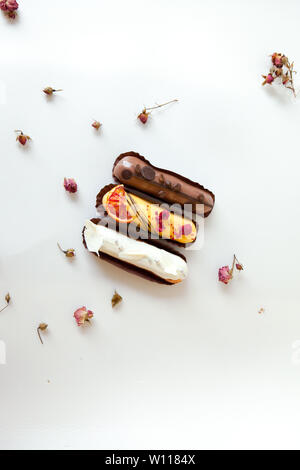 A set of three eclairs with different fillings and design isolate on a ...