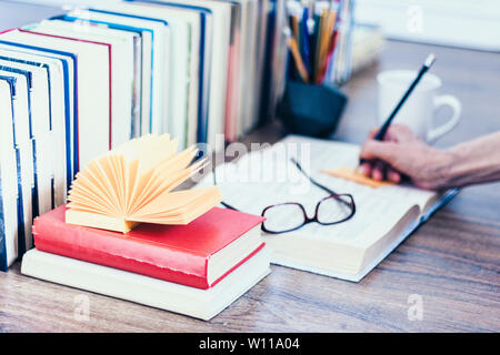 Woman with cup of coffee, bookmark and books on color background Stock ...