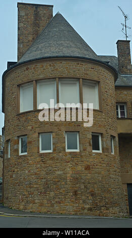 A historic brick building with a rounded tower and ornate spire against ...