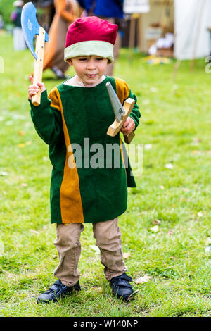 Medieval re-enactment event. Caucasian child, boy, blonde, sitting on ...