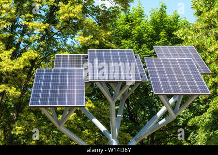 Solar panels stand against green mountains and blue sky at a ...