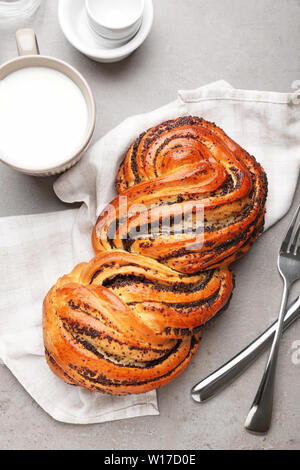 Tasty poppy bun with milk on grey table Stock Photo - Alamy