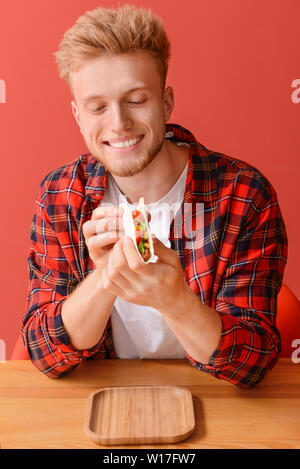 man eating tacos with vegetables on a black background. Blank space for ...
