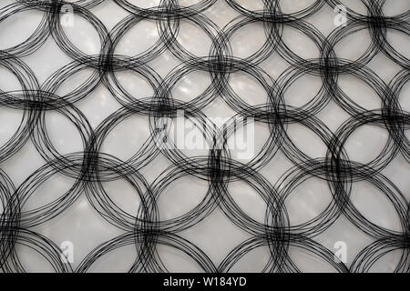 Abstract steel design tri-circle art design against wall. A nice ...