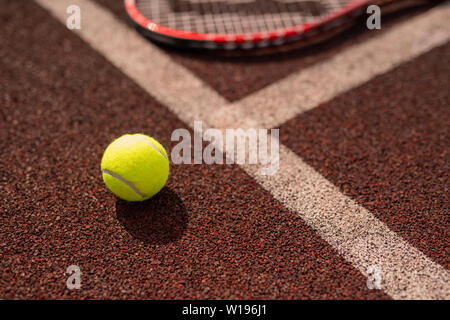 Yellow tennis ball with white line on blue court. Horizontal sport ...