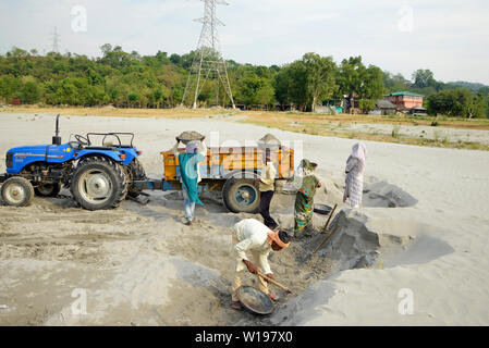 Manual worker loading sand on Tractor at River bank Stock Photo - Alamy