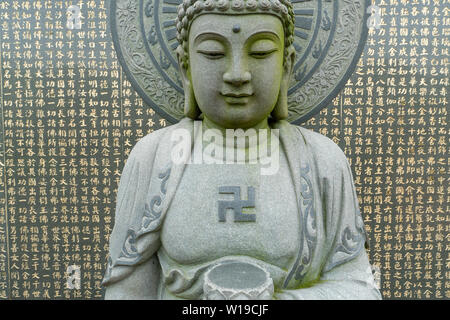 Statue of a Buddha with the Swastika Sign Stock Photo - Alamy