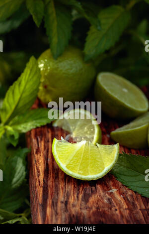 Slices of lime and mint on a wet black reflective background Stock ...