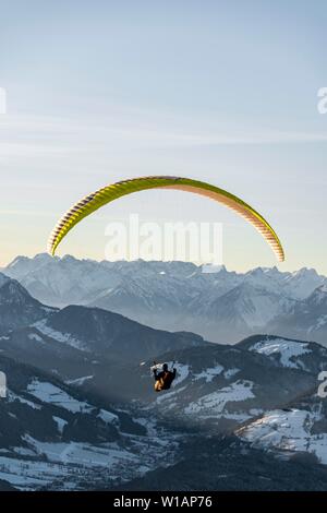 A paraglider in front of a snow covered mountain ridge in Switzerland ...
