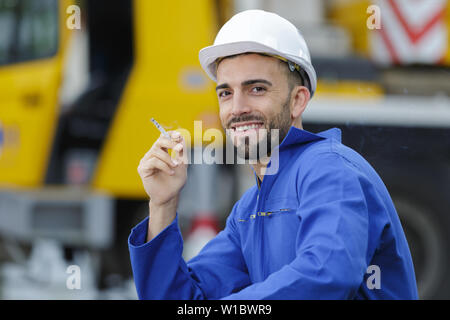 builder smoking cigarette on construction site Stock Photo - Alamy