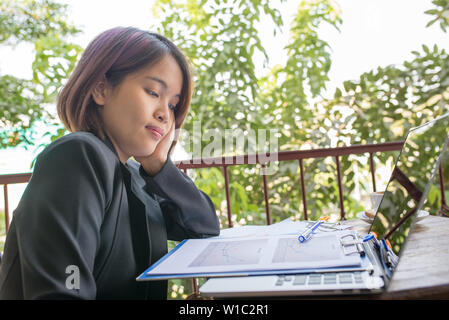 Businesswoman working with laptop keyboard and graph paper work ...