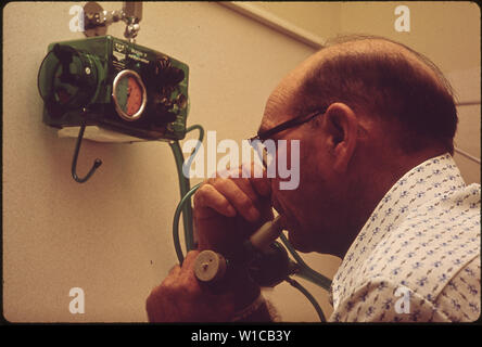 An emphysema patient uses a lung function testing machine to measure ...