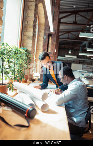 Team of interior designers drawing sketches for new projects on tablet ...