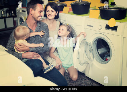 Home laundry. Smiling russian girl using washing machine at home Stock ...