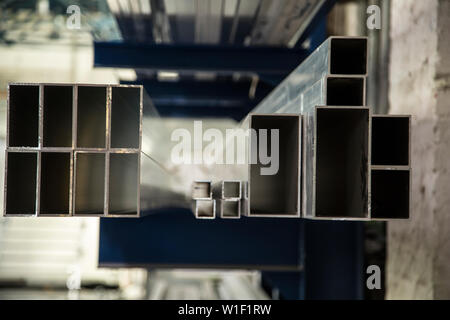 different sizes of rods piled up in old factory Stock Photo - Alamy