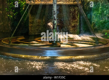 A spinning horizontal water mill as the water gushes in and creates the ...