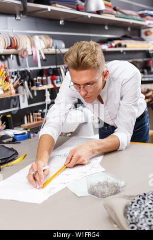 Professional male dressmaker at work – creating pattern at his ...