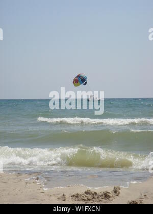 Parasailing over the sea. Flying a tandem paraglider over the sea with ...