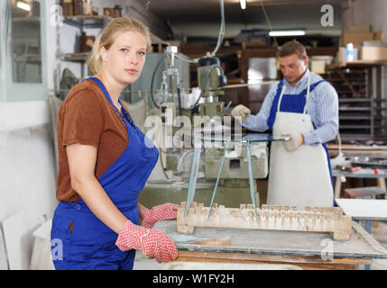 Portrait of qualified female glazier during daily work in glass factory ...