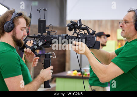 Behind the scene. Cameraman with his camera on outdoor set ...