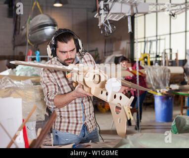 Male aircraft enthusiast working in workshop on creating of airplane ...