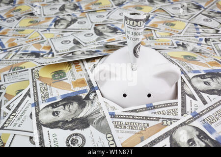 Piggy bank placed up to its nose in a pile of dollars Stock Photo - Alamy