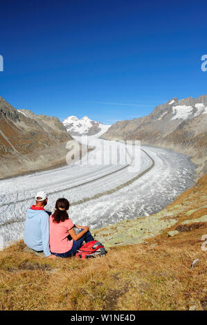 Couple looking towards glacier Grosser Aletschgletscher with Moench and ...