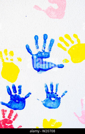 Children's handprints. Blue and yellow palm prints on a white sheet of ...
