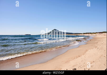 Moledo beach on a spring day, with waves on the sea and a mountain in ...