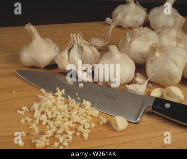Garlic bulb and cloves of garlic on knife, Allium sativum Stock Photo ...