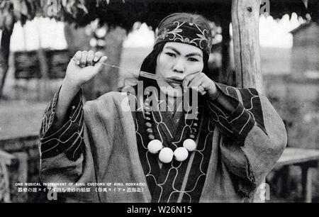 Ainu woman playing a traditional instrument in Ainu village museum ...