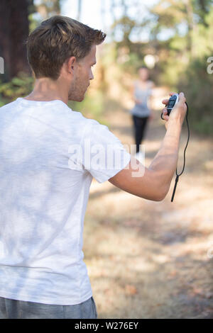 Coach holding Stopwatch Timing Runner Stock Photo - Alamy