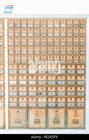 Rows of mid-century modern design post office mailboxes in brass metal ...