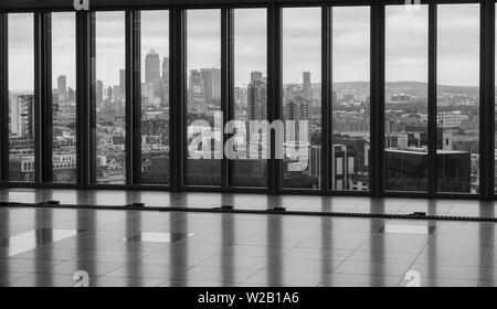 London skyline seen through ceiling high windows in an office building ...