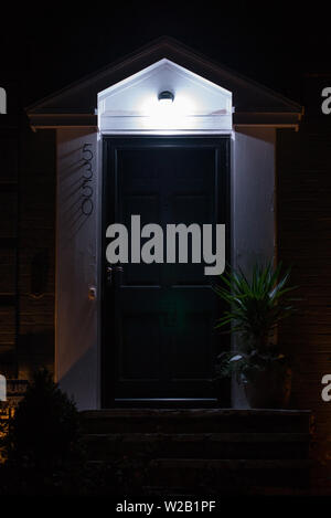 Lit up foyer entryway porch of house at night Stock Photo - Alamy