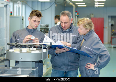 Engineers in mechanical factory reading instructions Stock Photo - Alamy