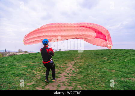 Skydiver pulls parachute behined him after landing Stock Photo - Alamy