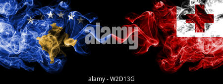 Tonga and Kosovo flag waving in the wind against white cloudy blue sky ...