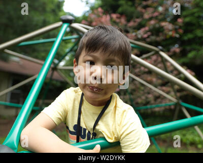portrait of boy in play structure making funny face Stock Photo - Alamy