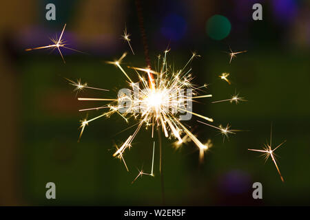 Sparks from hand cold fireworks color background Stock Photo - Alamy