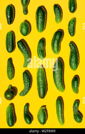 Different sizes forms cucumbers pattern on a light yellow background ...