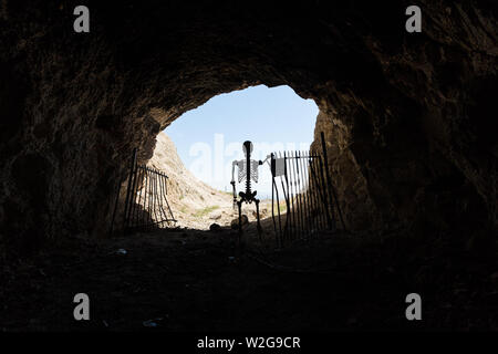 Skeleton silhouette in the mouth of a gated mine stay out stay alive ...