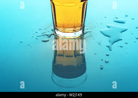 Bubbling yellow fizzy soda drink in glass, close up with selective ...