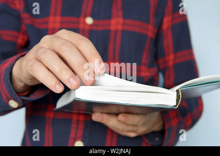man holding book flicking through pages Stock Photo - Alamy
