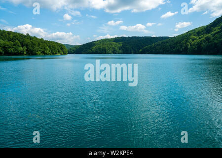 Beautiful turquoise lake surrounded by lush green trees in Plitvice ...