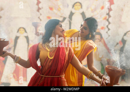 Two bengali women performing dhunuchi dance on the occasion of durga ...