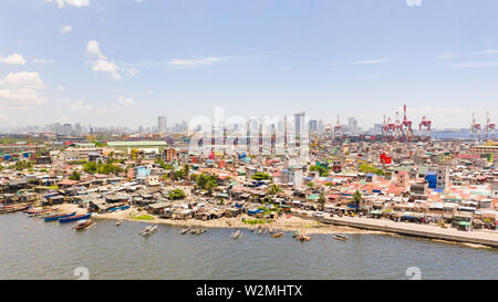 The urban landscape of Manila, with slums and skyscrapers. Sea port and ...