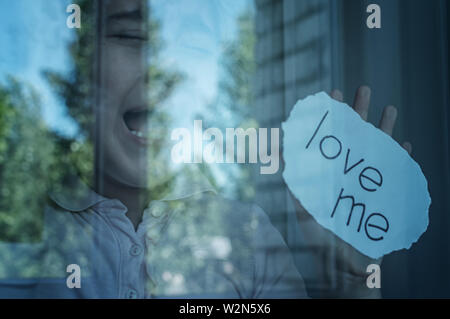 girl crying at the window with a note in his hand Stock Photo - Alamy